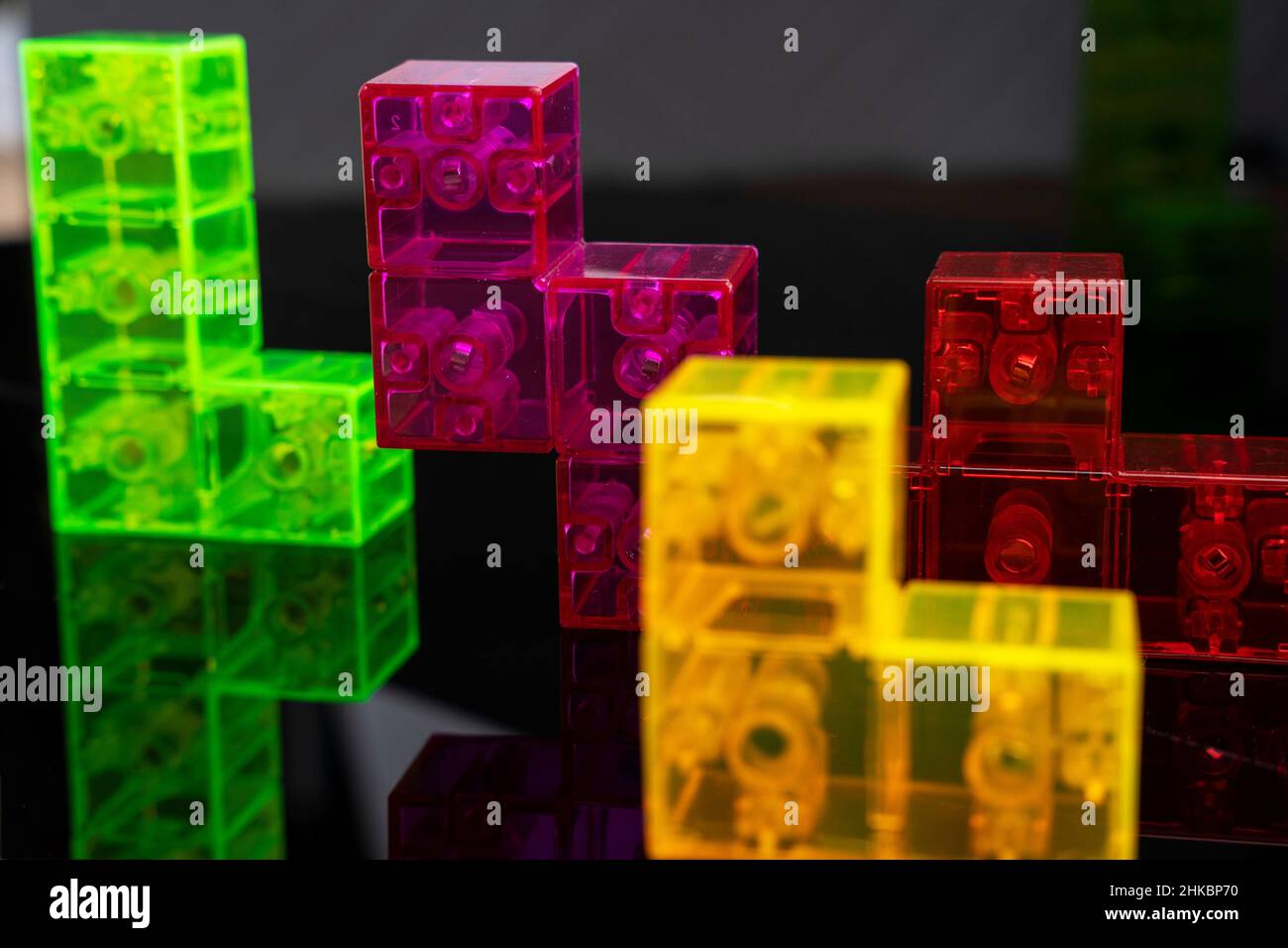 three-dimensional tetris. scattered colored tetris figures on glossy ...