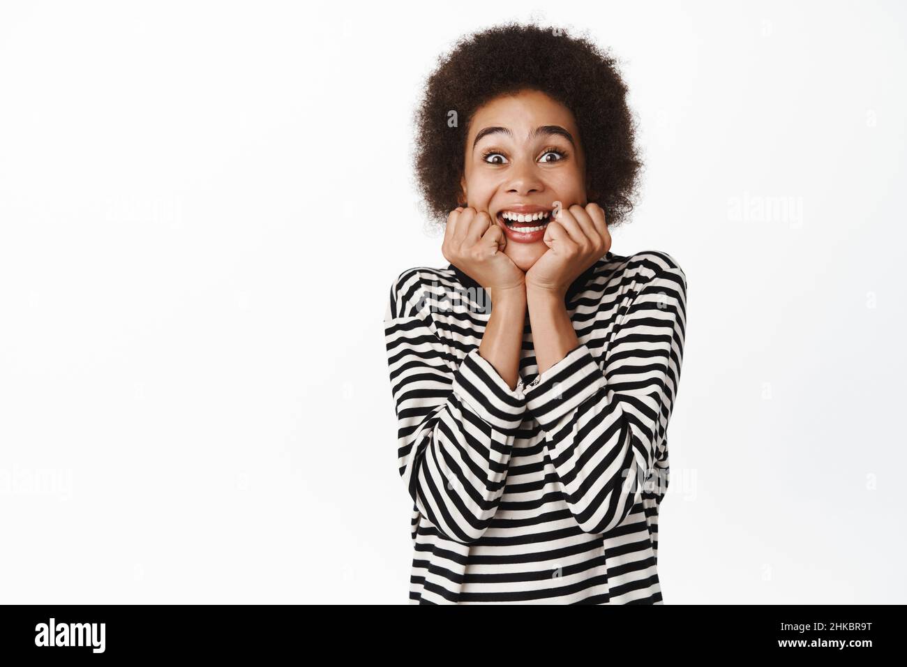 Image of excited african girl gasping in awe, looking surprised and ...