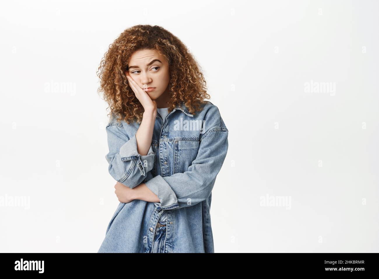 Bored young woman, facepalm and look aside with annoyed, unamused face ...