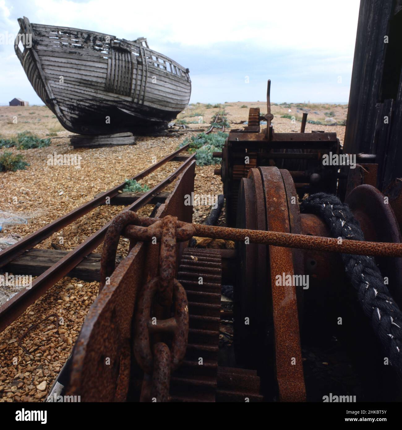 Machine for dragging boat onto shingle with beached and wrecked boat on ...