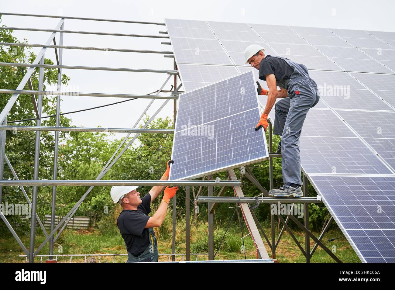 Male worker in safety construction helmet giving solar module to ...