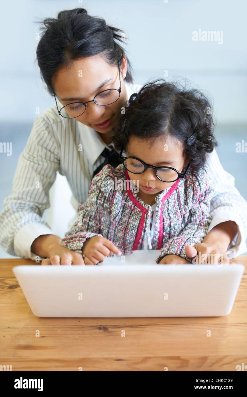 Following in mommy's footsteps. A cute little girl sitting on her ...