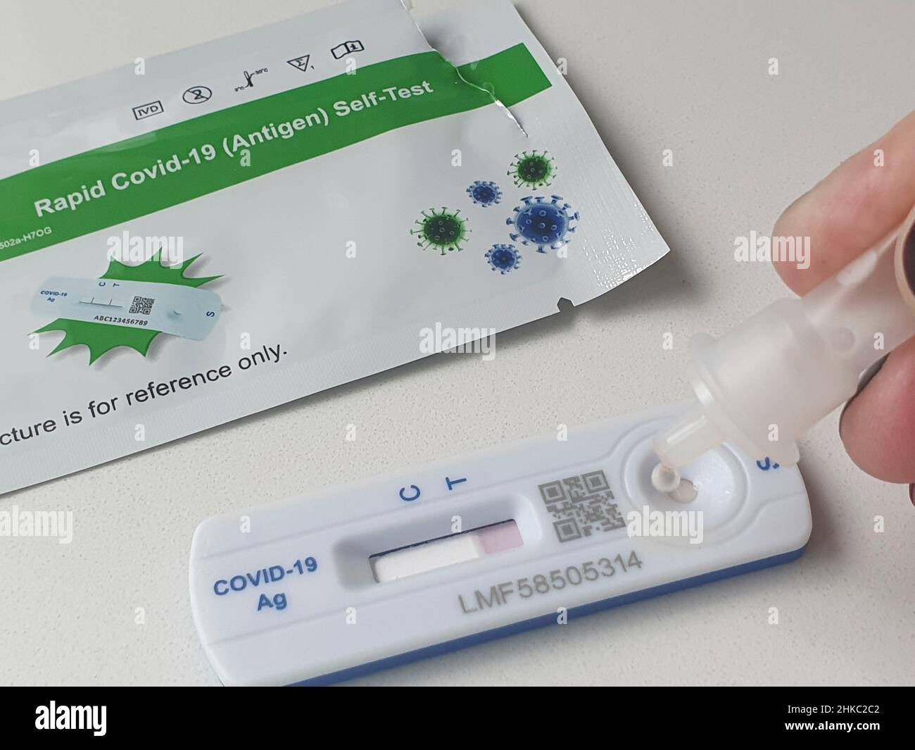 London, UK, 3 February 2022: a person places four drops of buffer ...