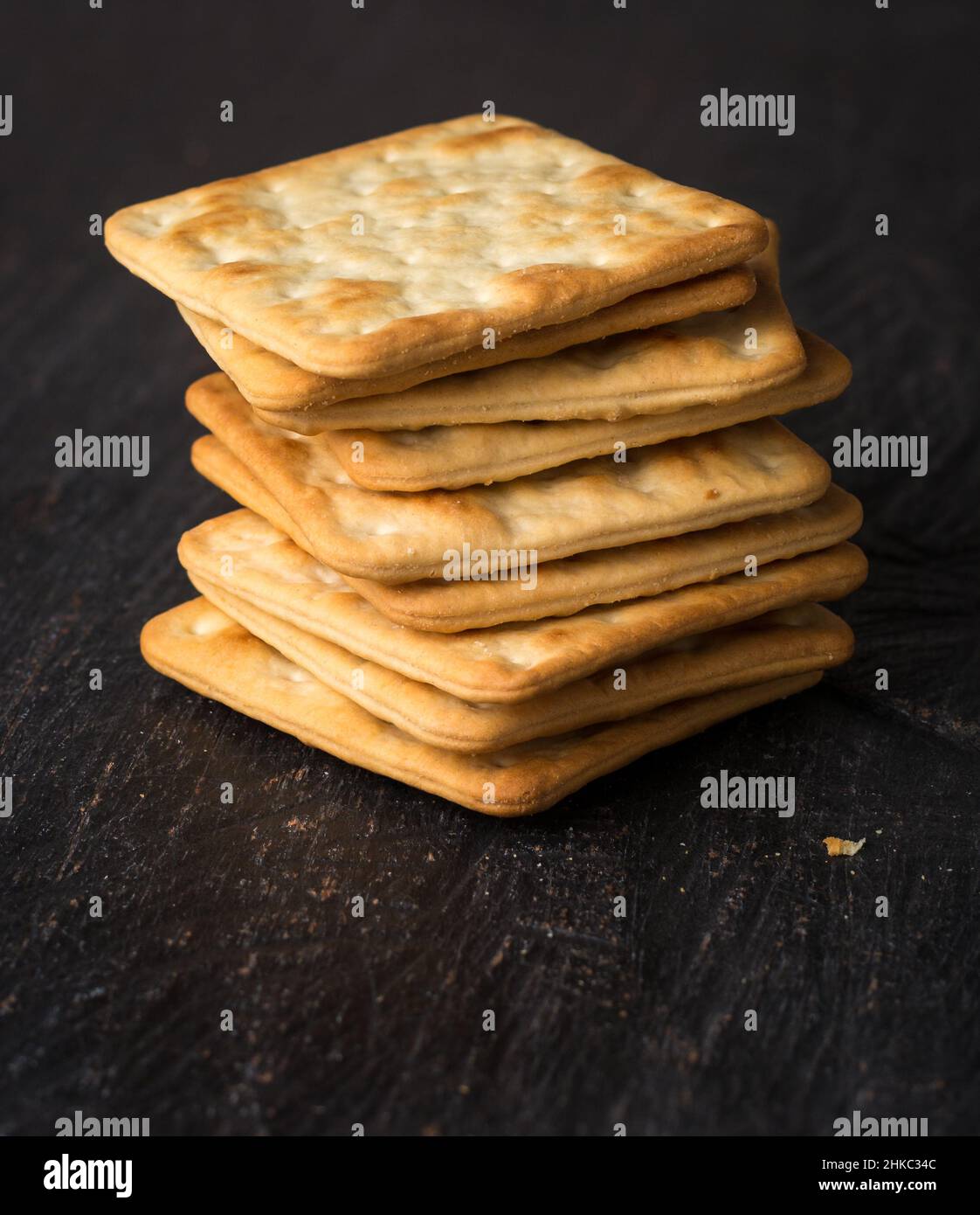 stack of biscuits on a black table top, crispy and crunchy square shape ...