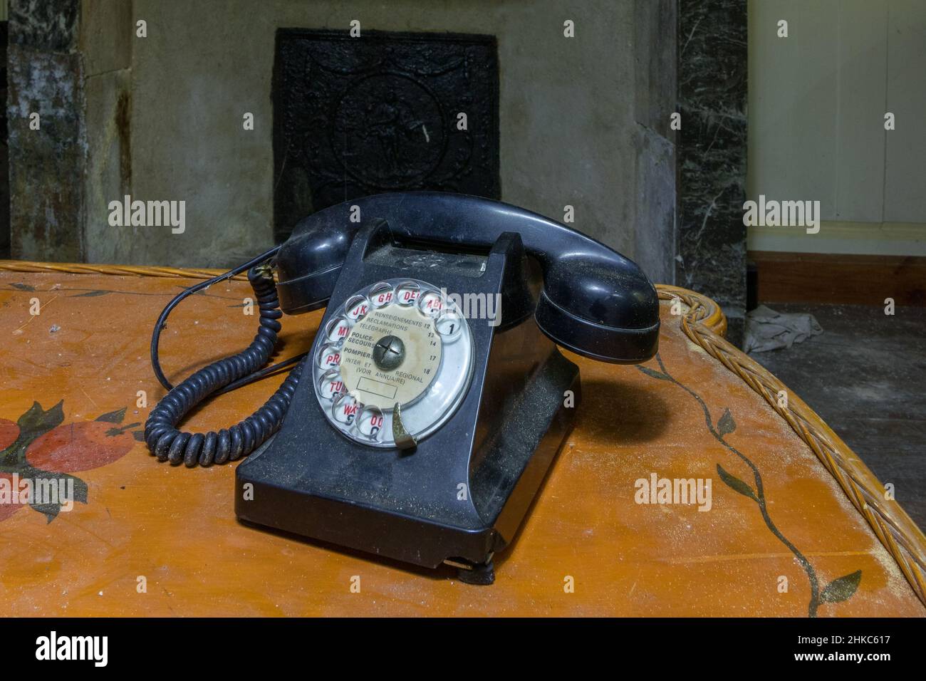 Very old black telephone with dial stands on a table in an old ...