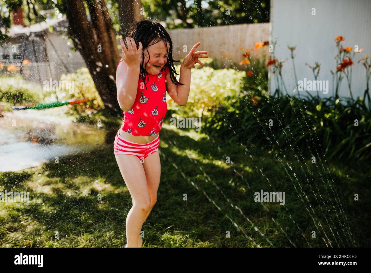 Close up of young girl getting sprayed in the face by a sprinkler Stock ...