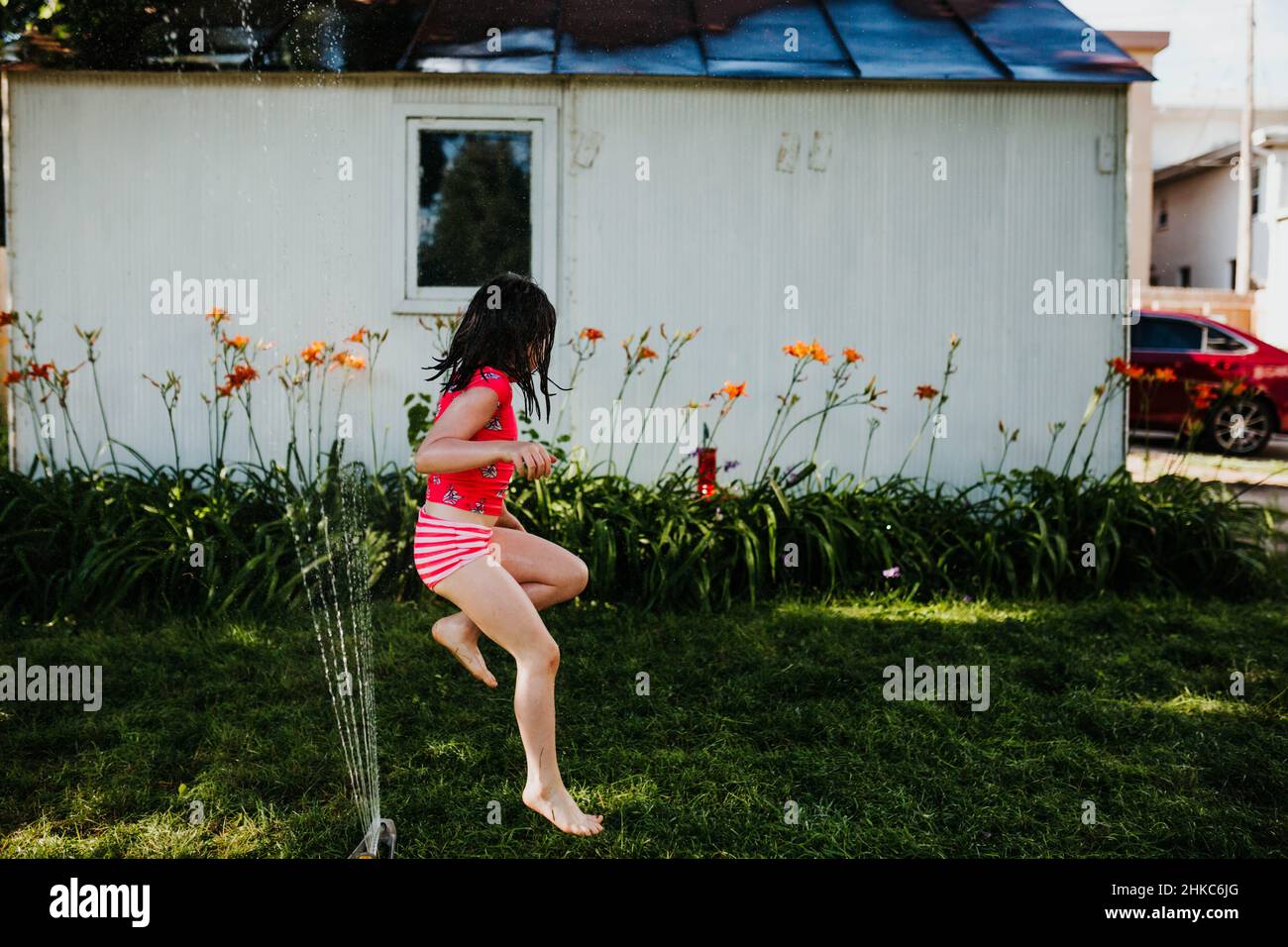 Young girl runs through sprinkler in backyard during summer Stock Photo - Alamy