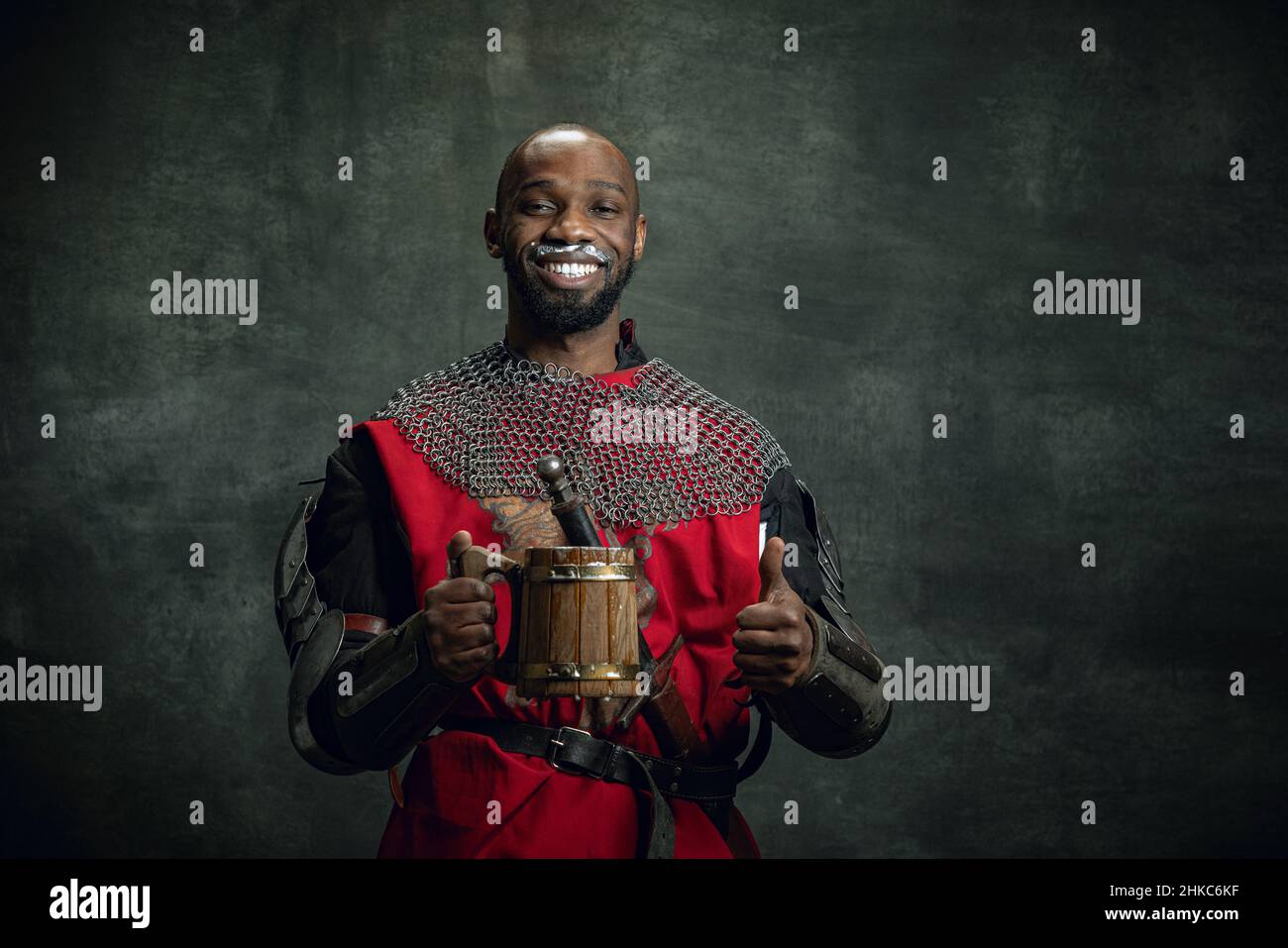 Cheerful man in image of medieval warrior, knight wearing war armor ...