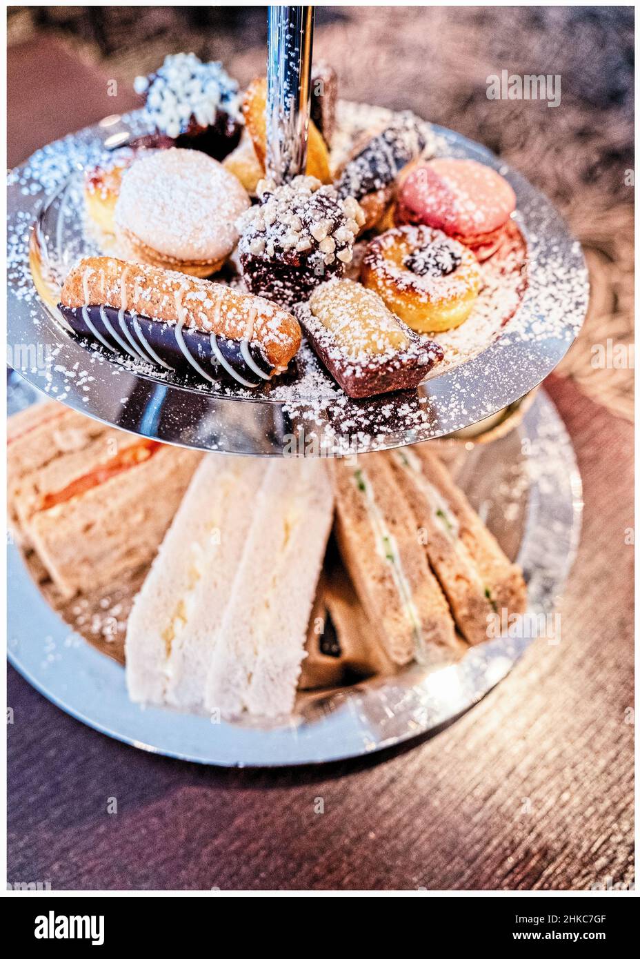 Delicious cake stand full of fancy cakes and sandwiches for English ...