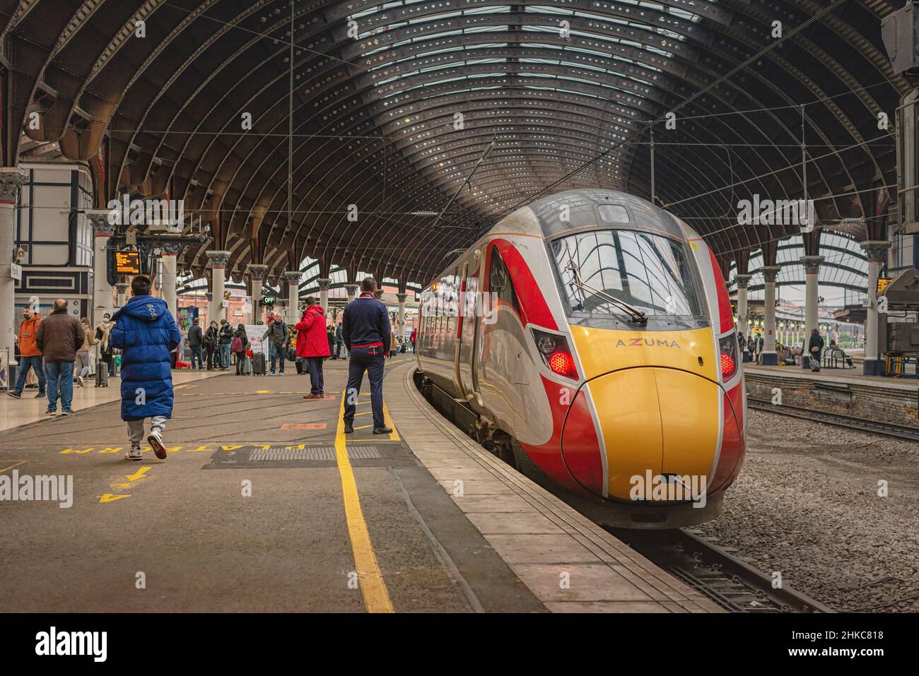 Railway station platform with a train alongside. Overhead is an ...