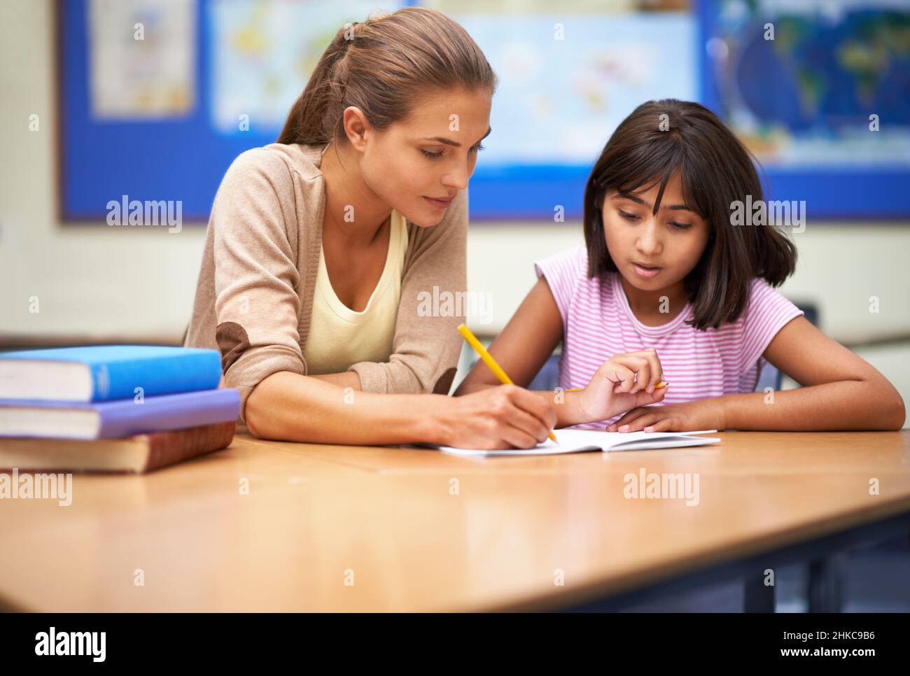 She's a dedicated educator. Shot of a teacher helping her student with ...