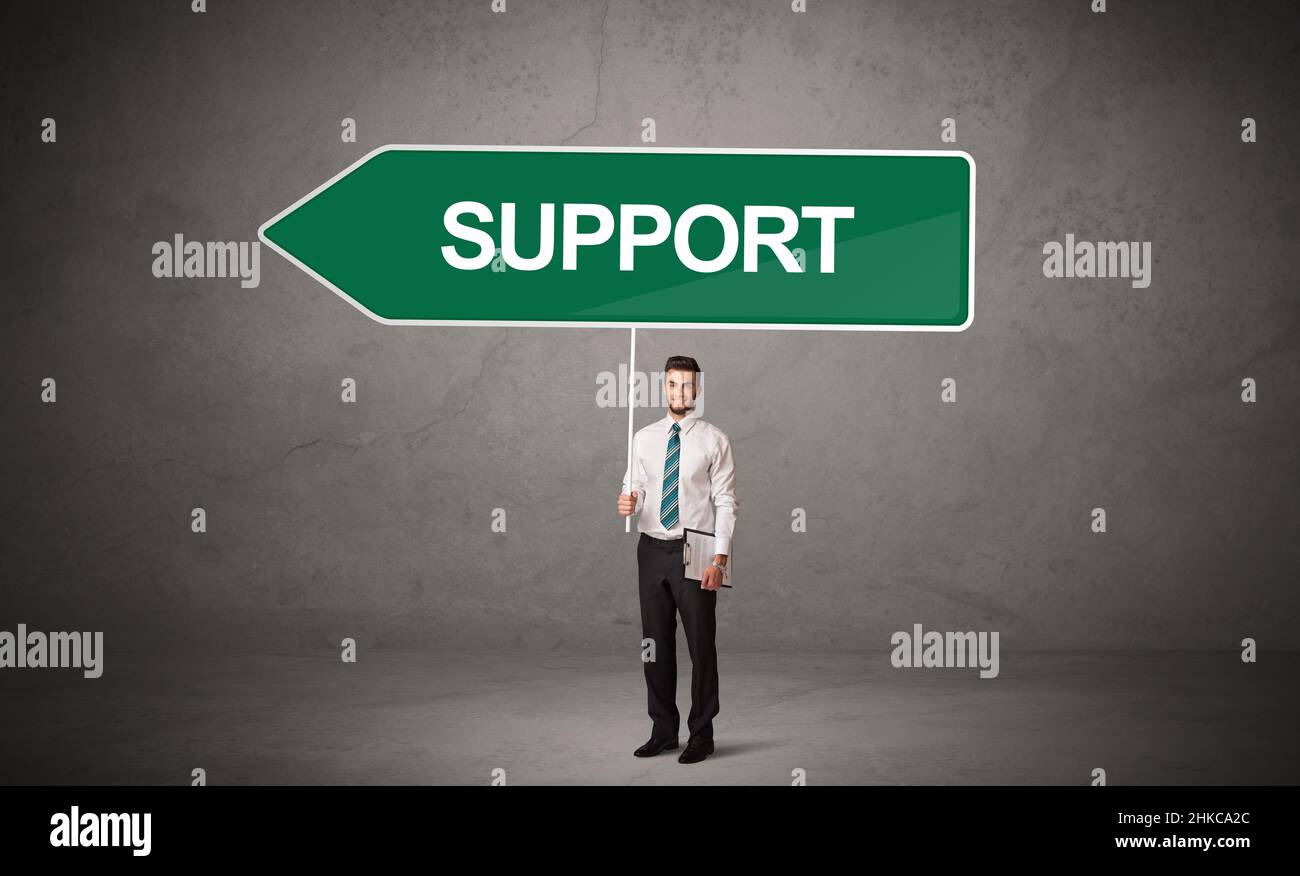 Young business person in casual holding road sign Stock Photo - Alamy