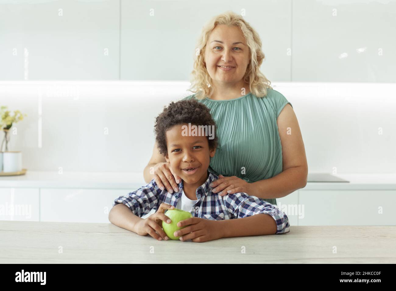Cute child boy with black hair and her mom smiling indoors. Happy ...