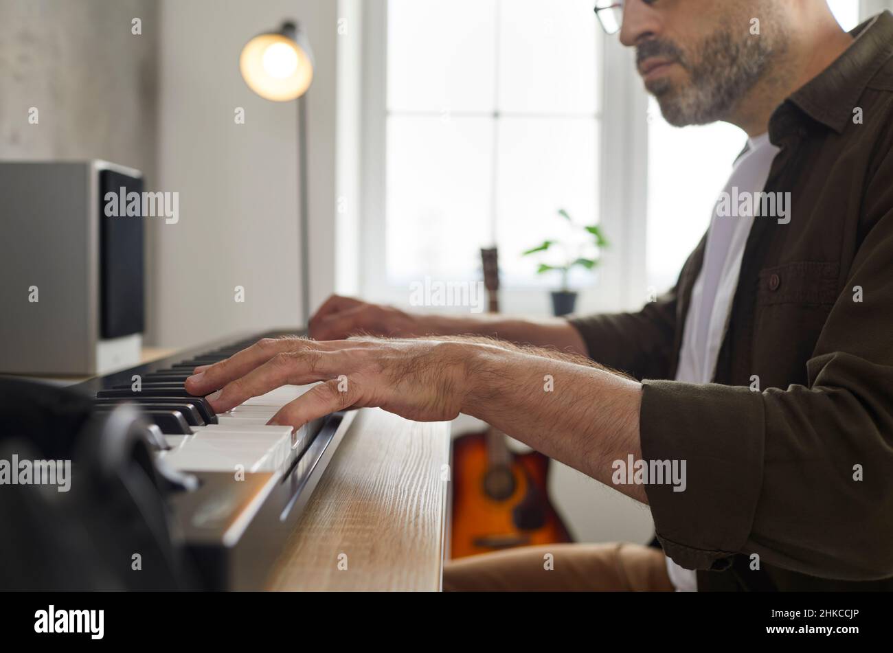 Close up of hands of professional male musician playing on synthesizer ...