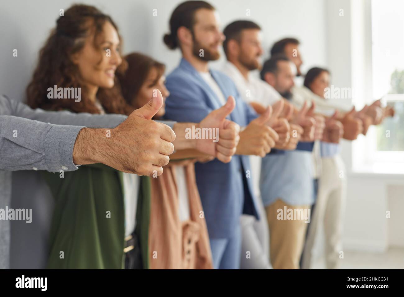 Group of happy business people standing in row and giving thumbs up all ...