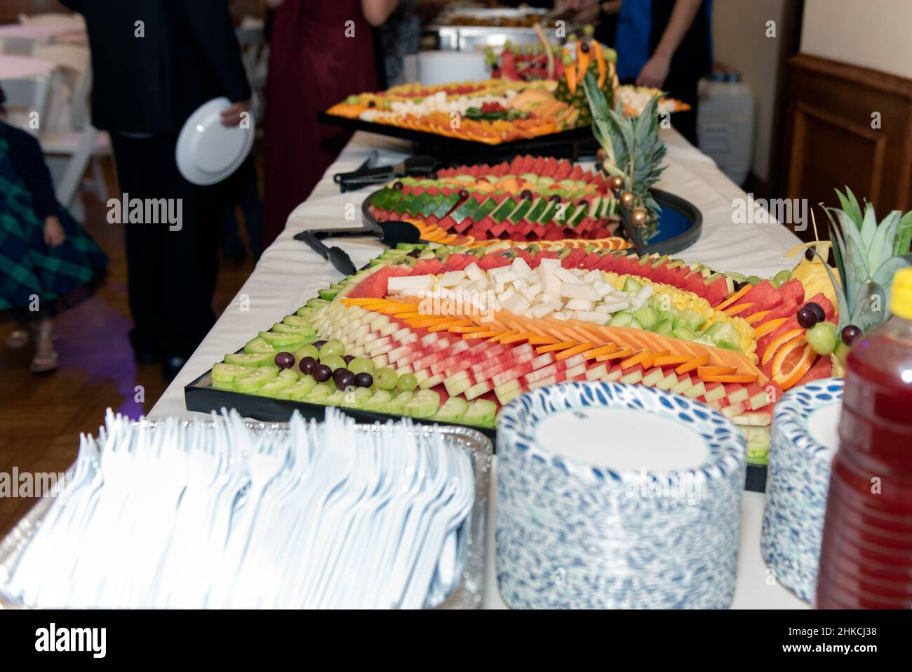 Buffet table has a decorative display of sliced fruit stacked into ...