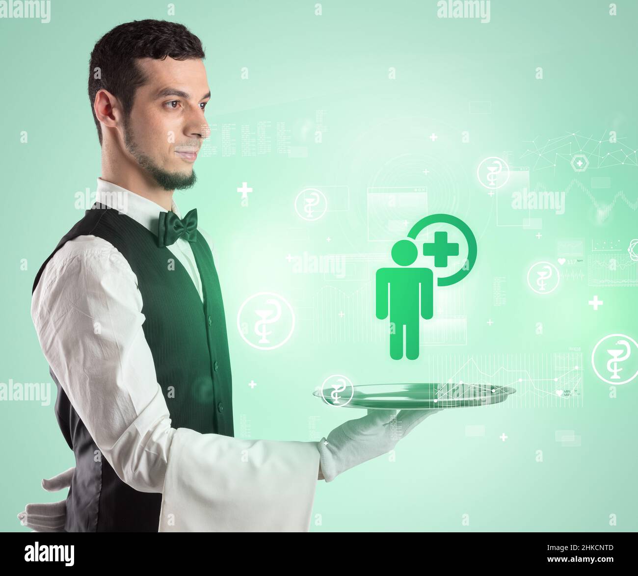 Handsome young waiter in tuxedo holding healthcare icons on tray Stock ...