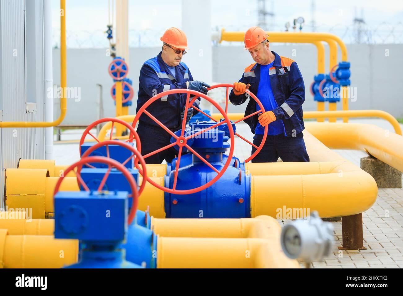 A uniformed worker opens a valve to control gases Stock Photo - Alamy