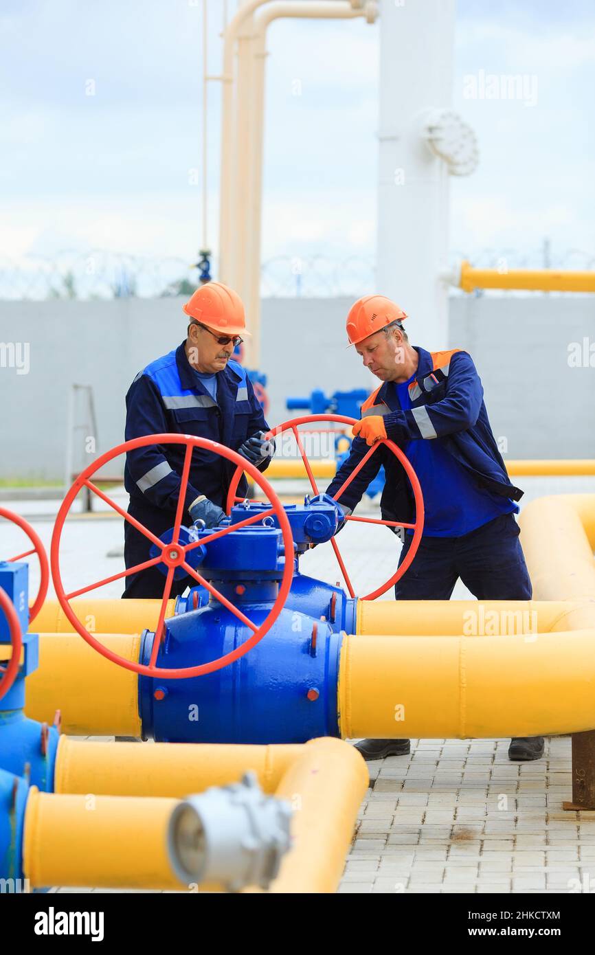 A uniformed worker opens a valve to control gases Stock Photo - Alamy