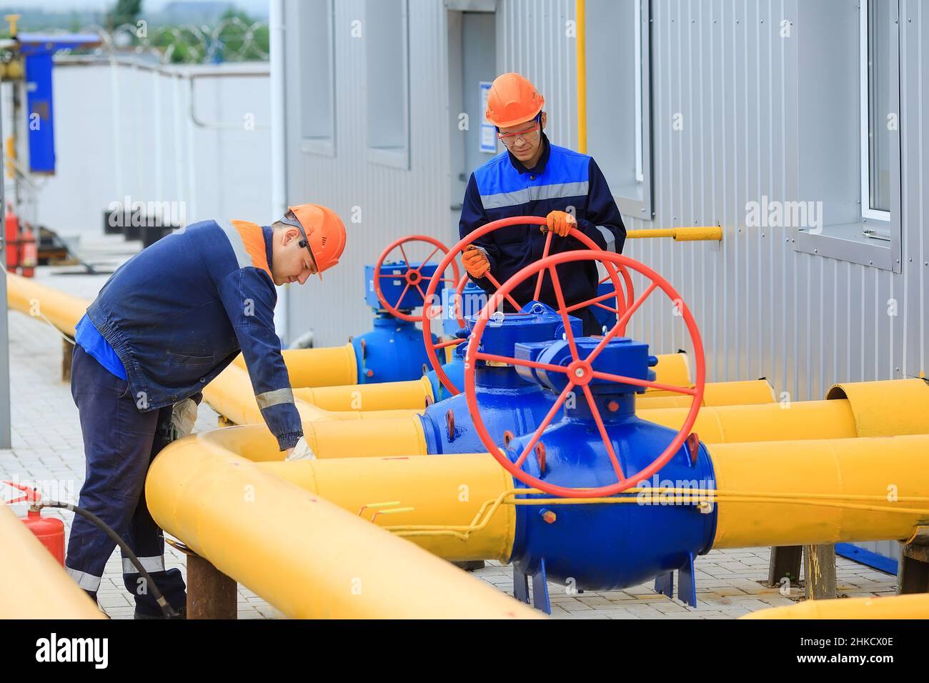 A uniformed worker opens a valve to control gases Stock Photo - Alamy