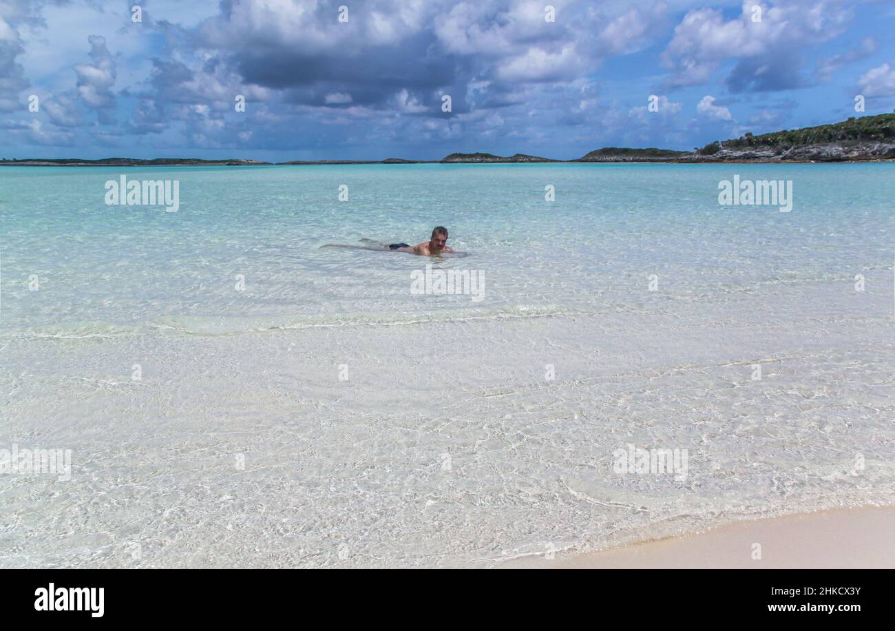 Beautiful view of man floating in Atlantic ocean on sandbar with white ...