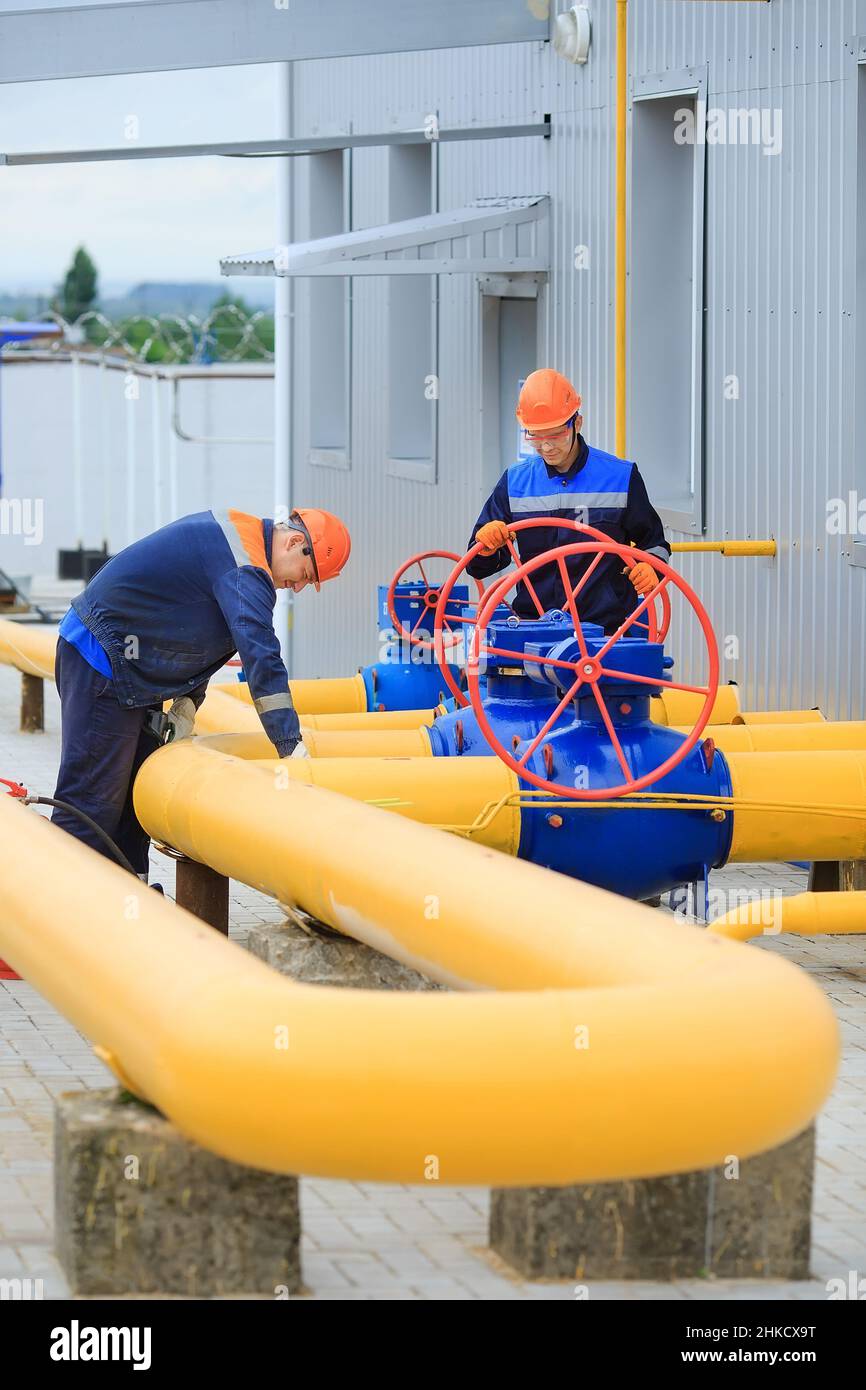 A uniformed worker opens a valve to control gases Stock Photo - Alamy
