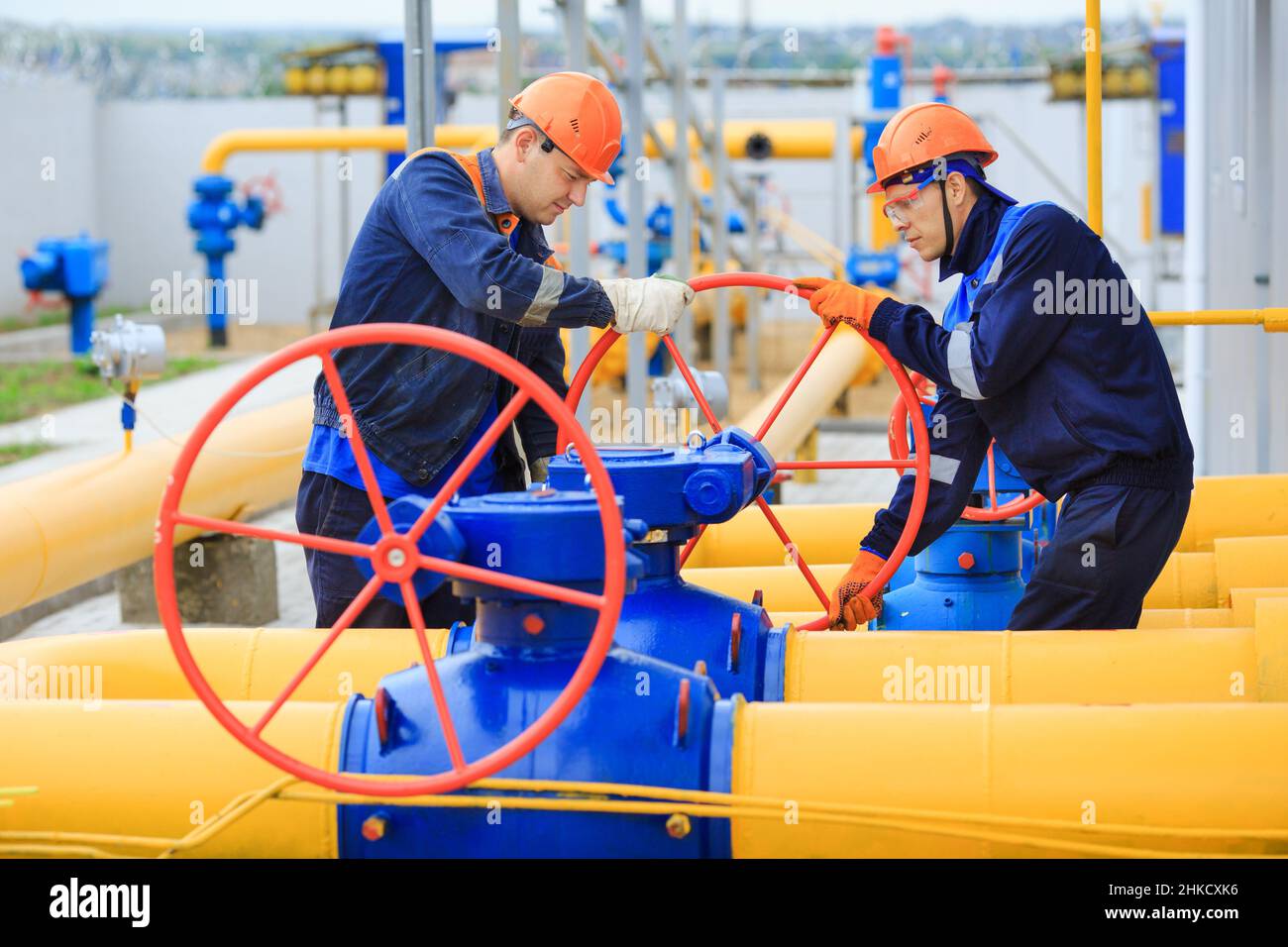 A uniformed worker opens a valve to control gases Stock Photo - Alamy