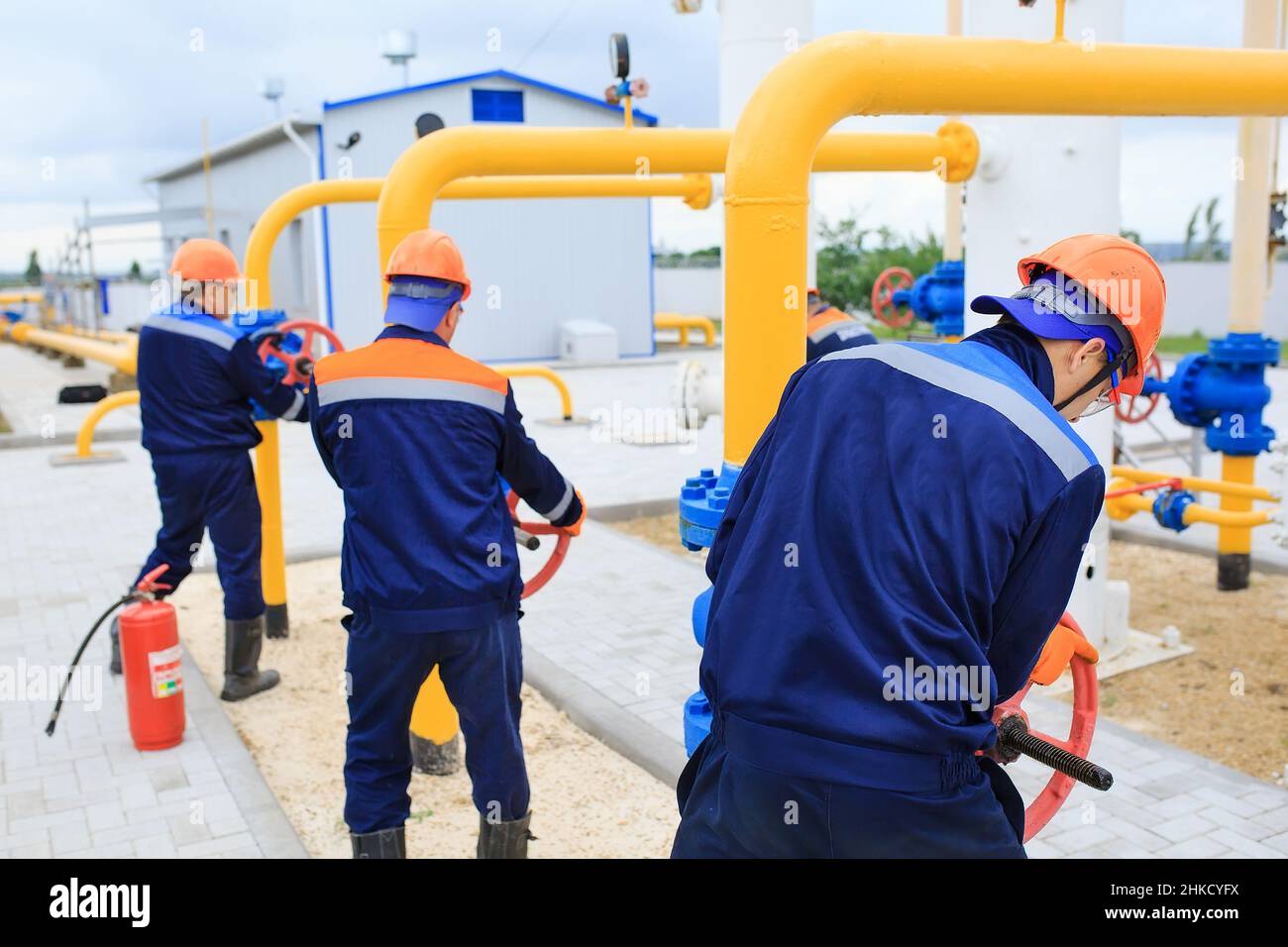 A uniformed worker opens a valve to control gases Stock Photo - Alamy