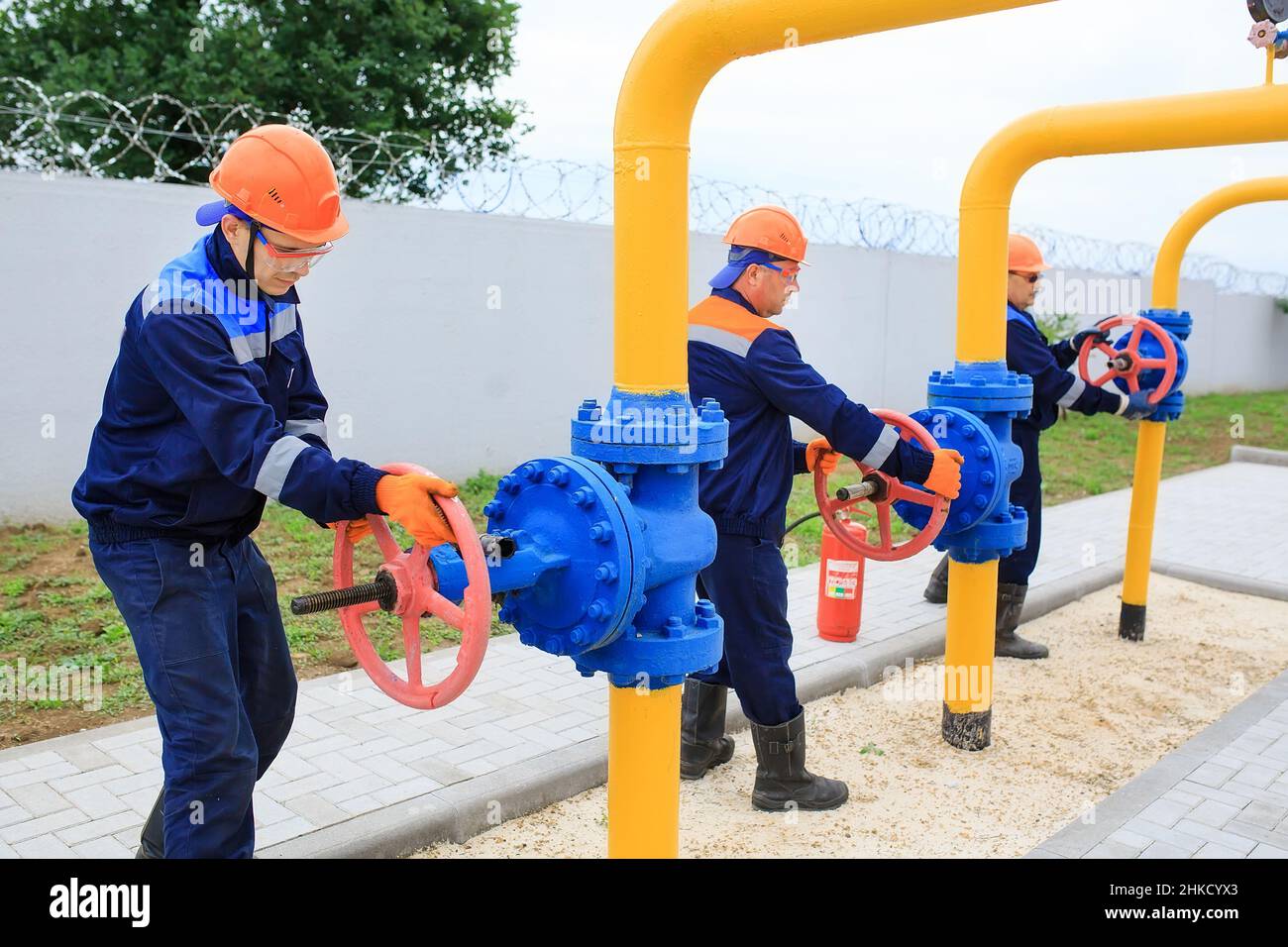 A uniformed worker opens a valve to control gases Stock Photo - Alamy