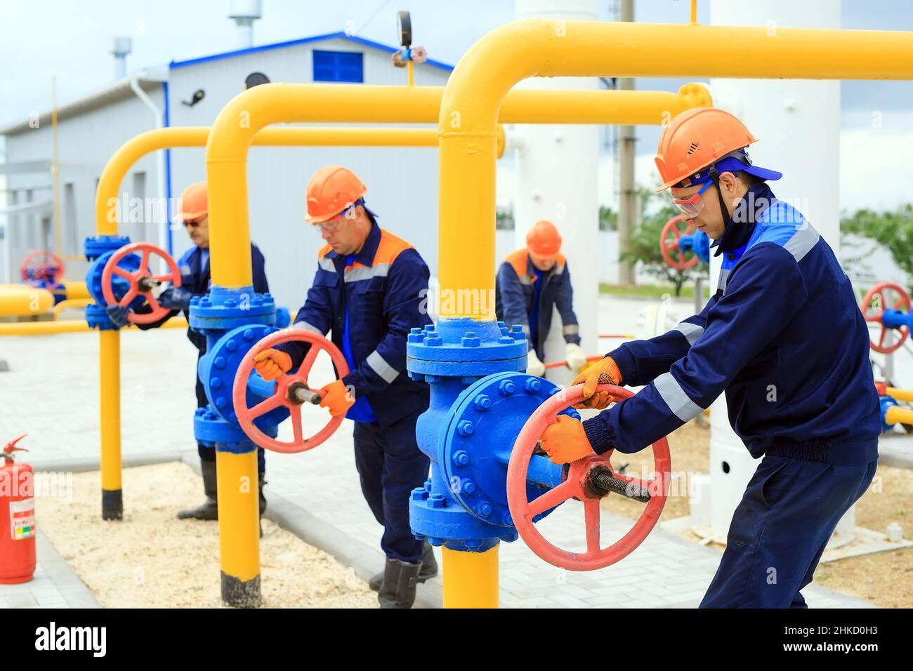 A uniformed worker opens a valve to control gases Stock Photo - Alamy
