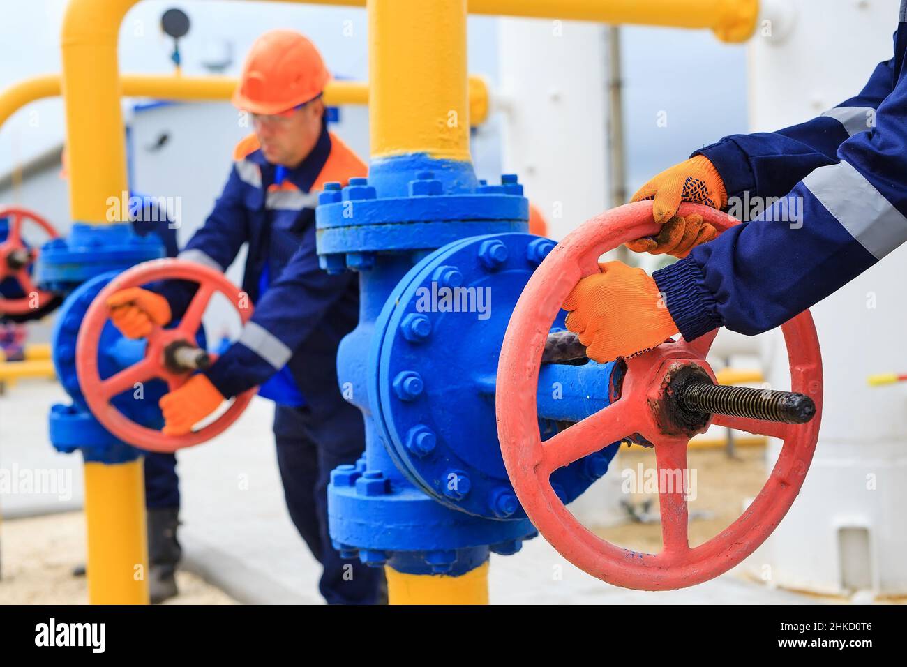 A uniformed worker opens a valve to control gases Stock Photo - Alamy