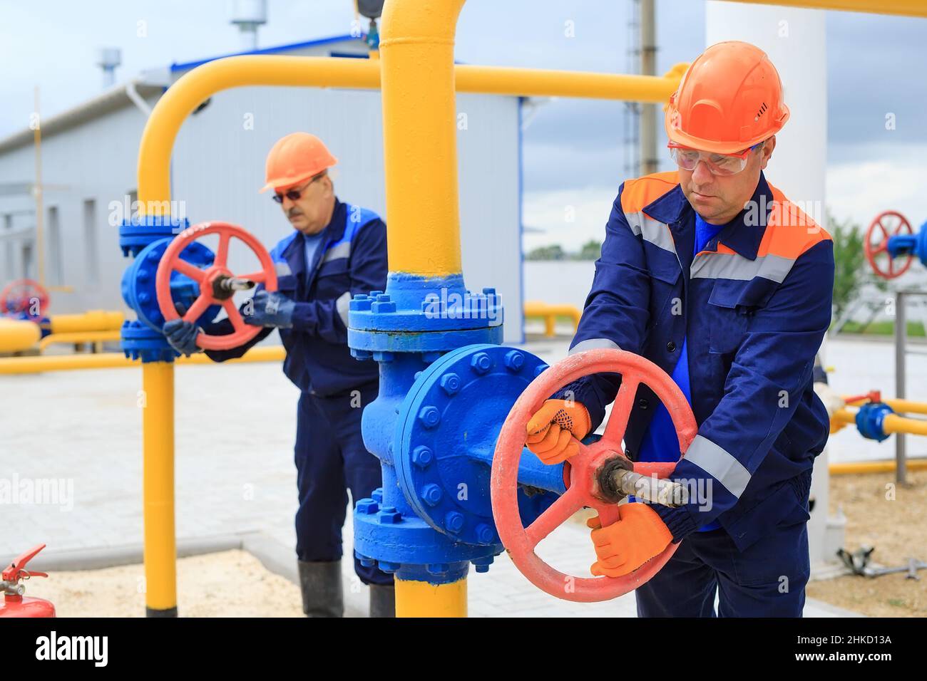 A uniformed worker opens a valve to control gases Stock Photo - Alamy