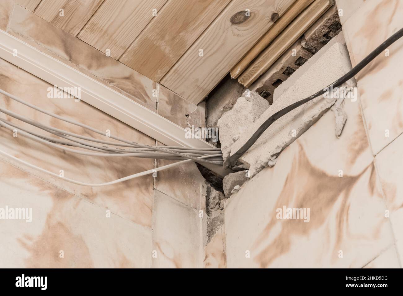 Old cable cord wiring insulation system on the wall near the ceiling ...