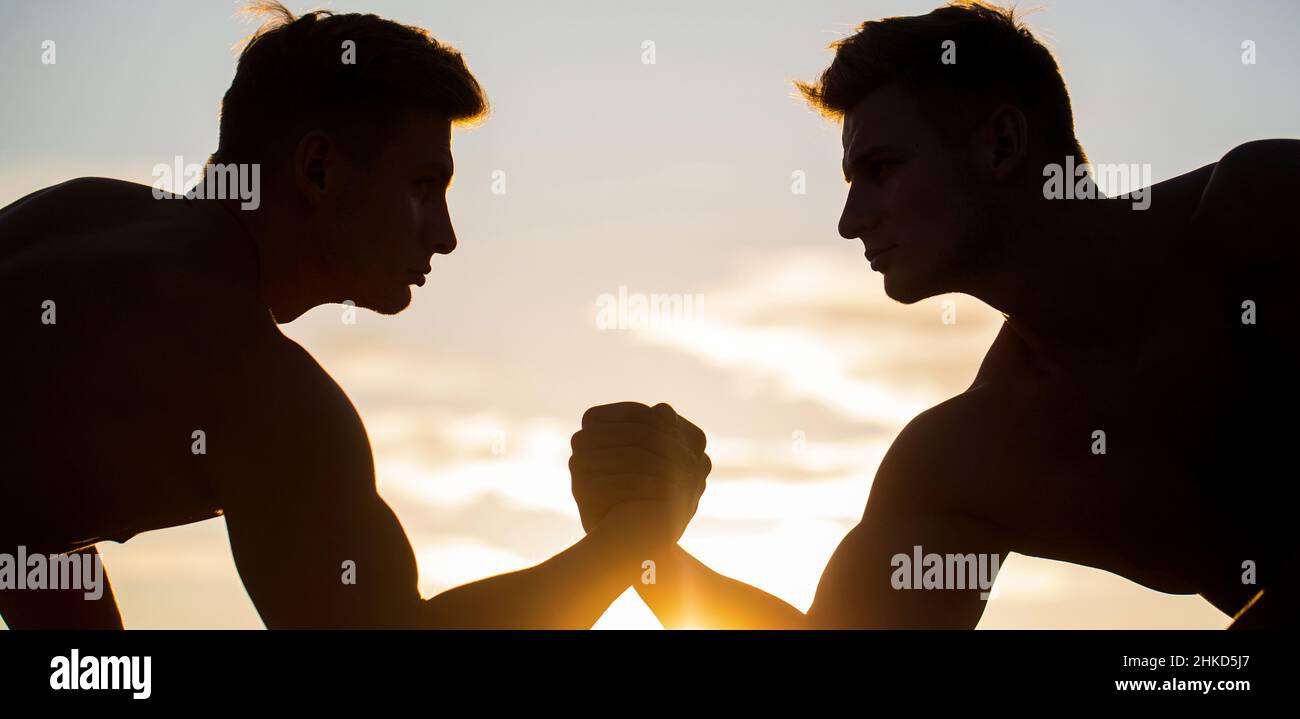 Silhouette of hands that compete in strength. Rivalry, closeup of male ...