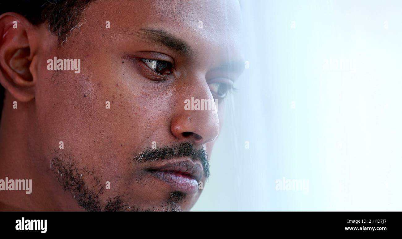 Person looking out window. Close-up African American descent man looks ...