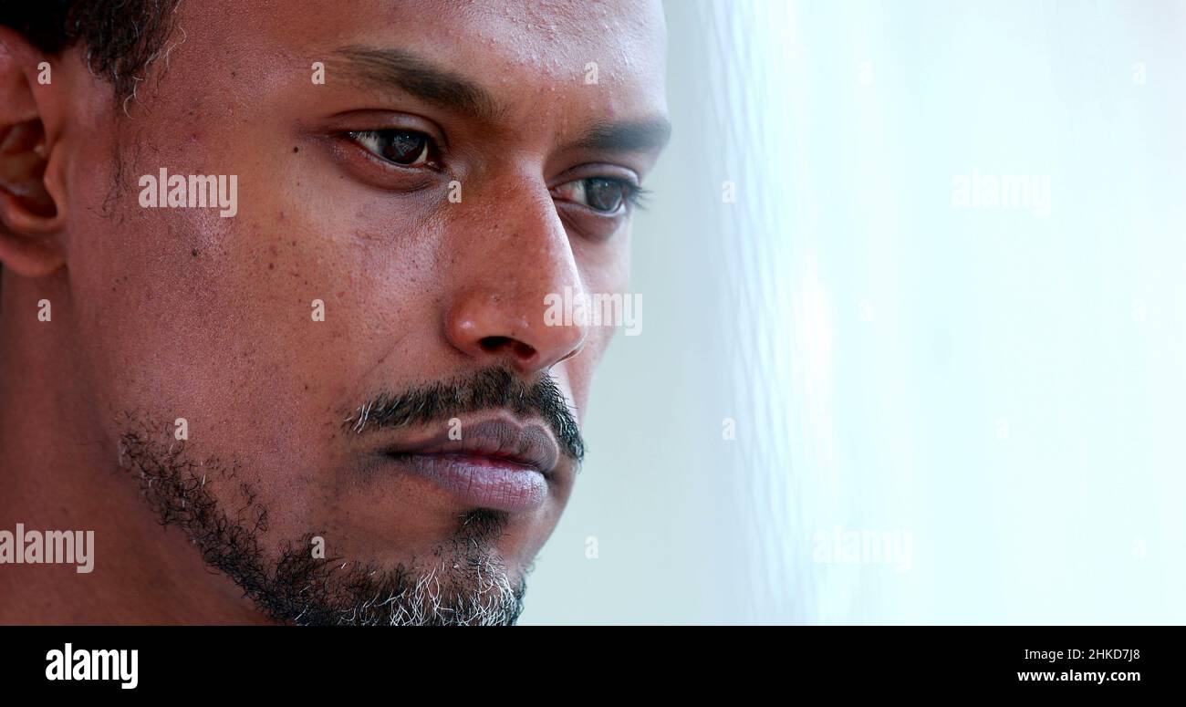 Person looking out window. Close-up African American descent man looks ...