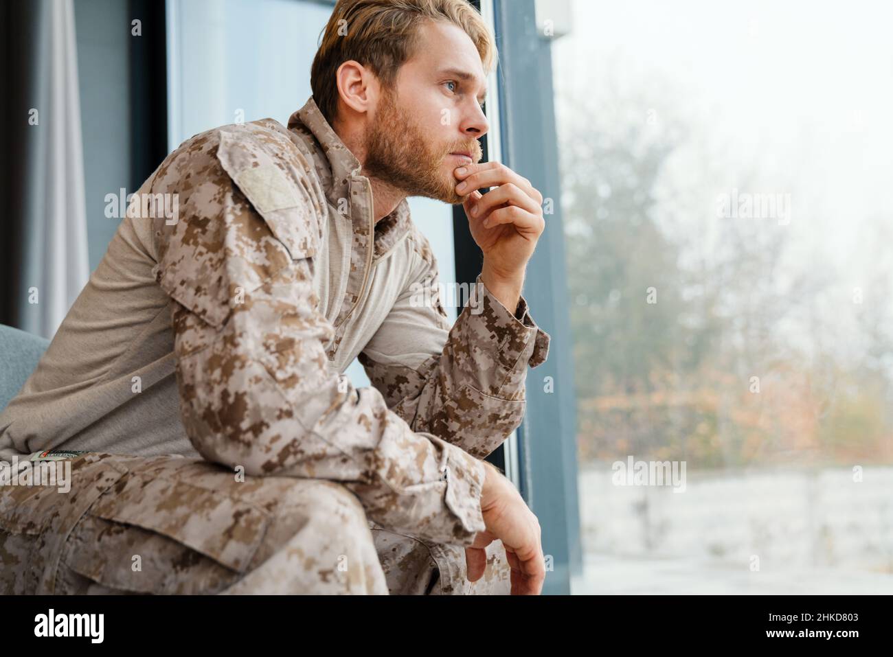 Masculine confident military man in uniform sitting and thinking ...