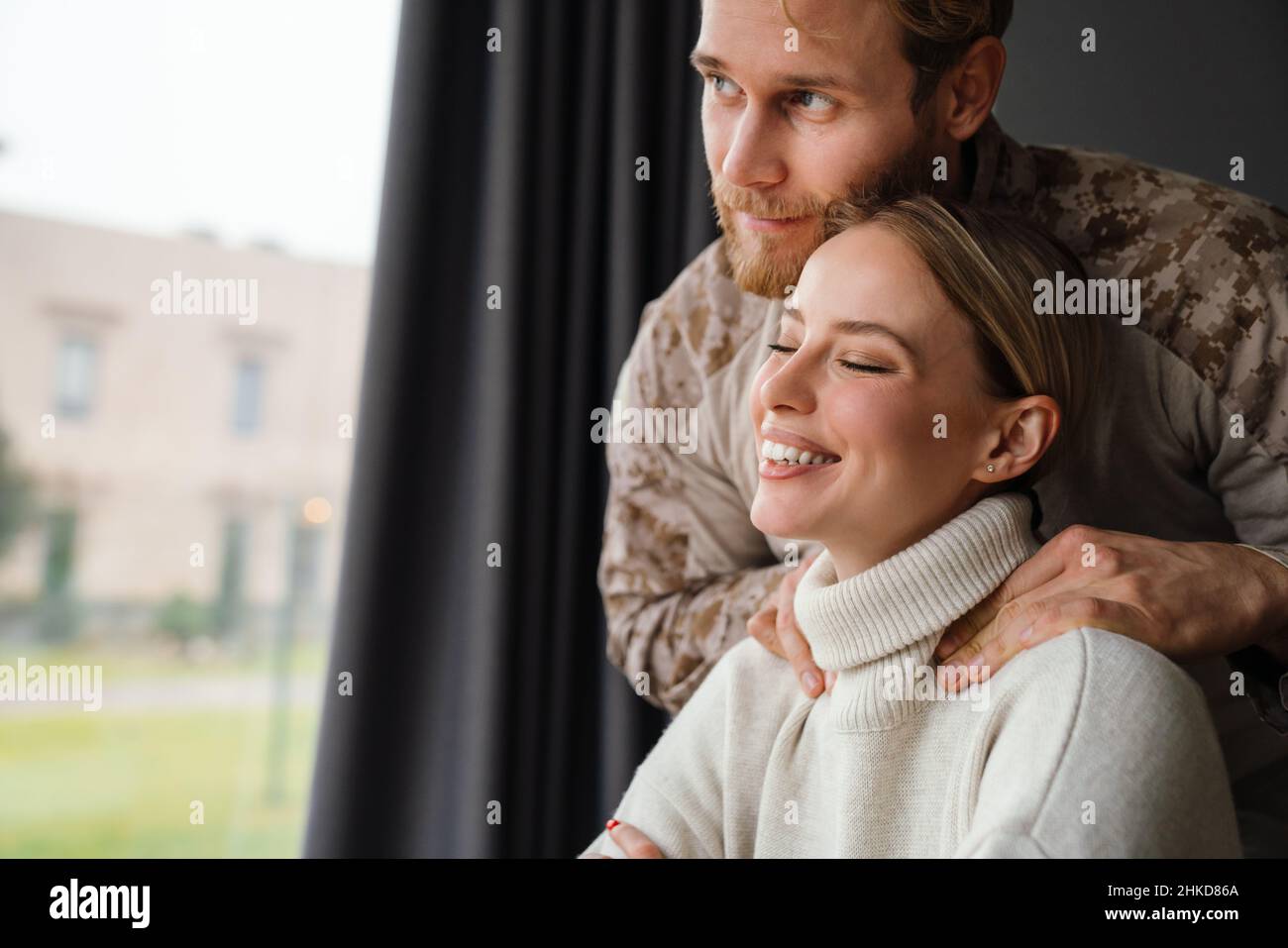 Beautiful happy couple talking and smiling while hugging at home Stock ...