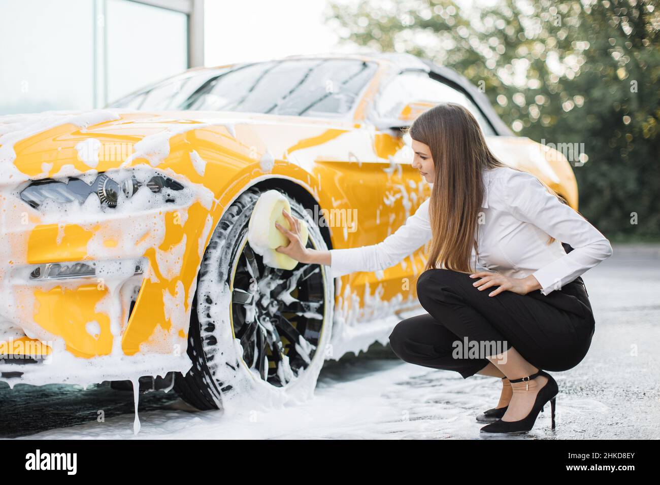Car detailing wash at outdoors car wash service. Attractive woman ...
