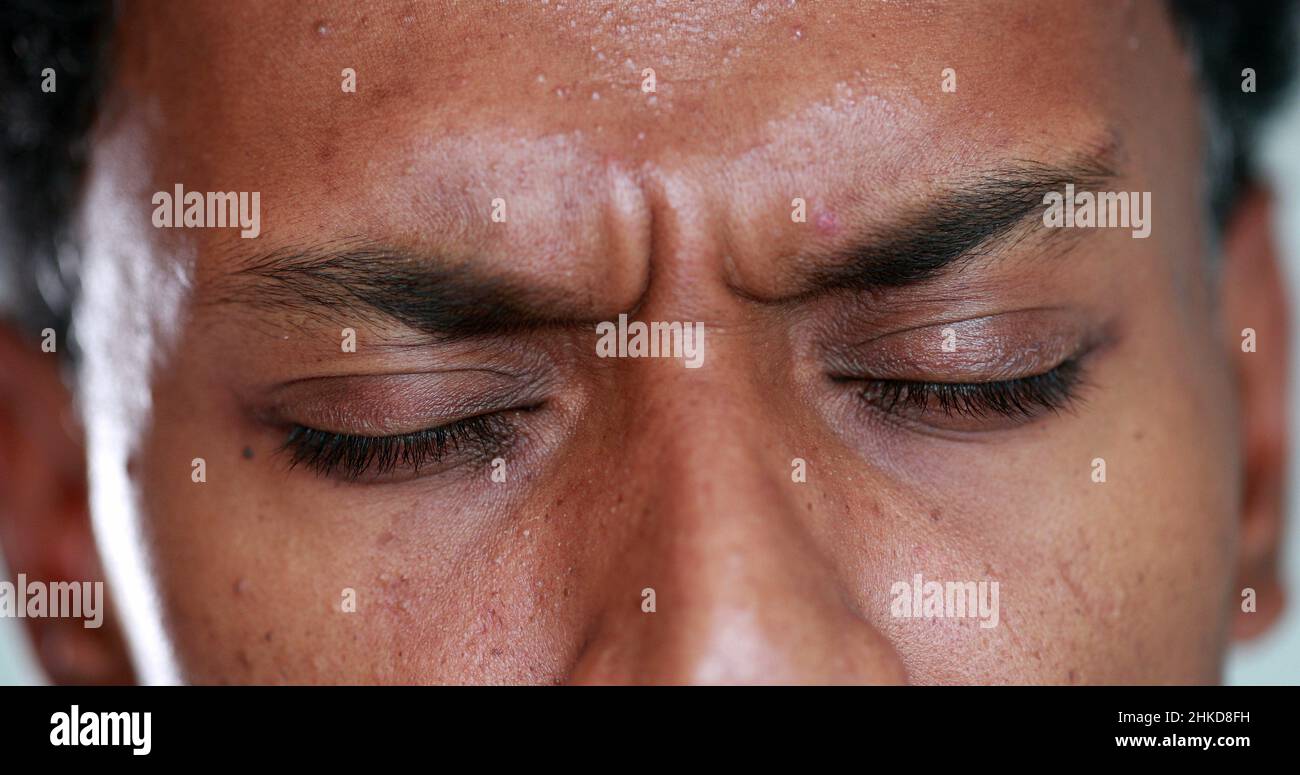 Worried African man closing eyes in contemplation. Concerned ...