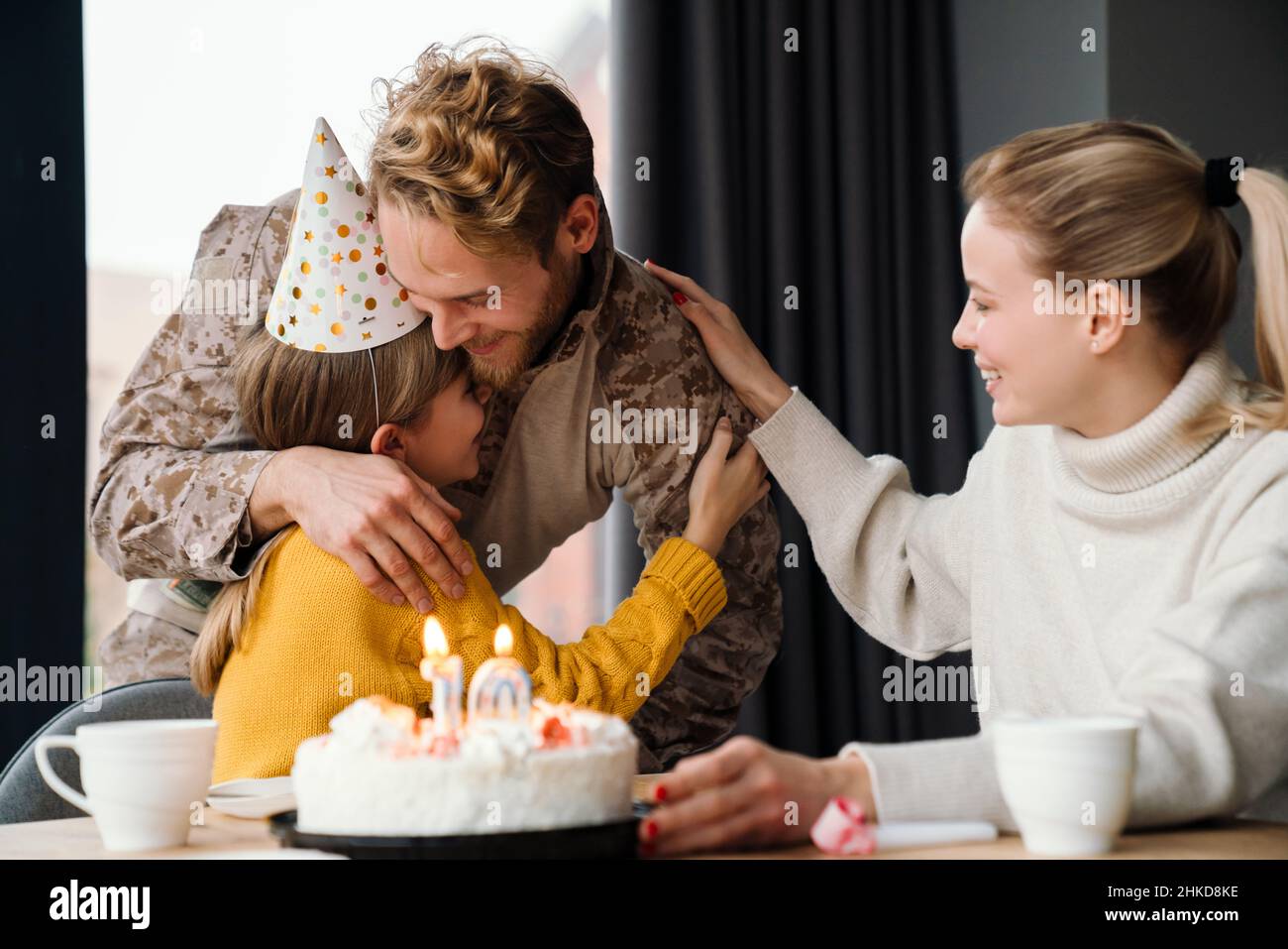 Beautiful happy family hugging while celebrating birthday of daughter ...