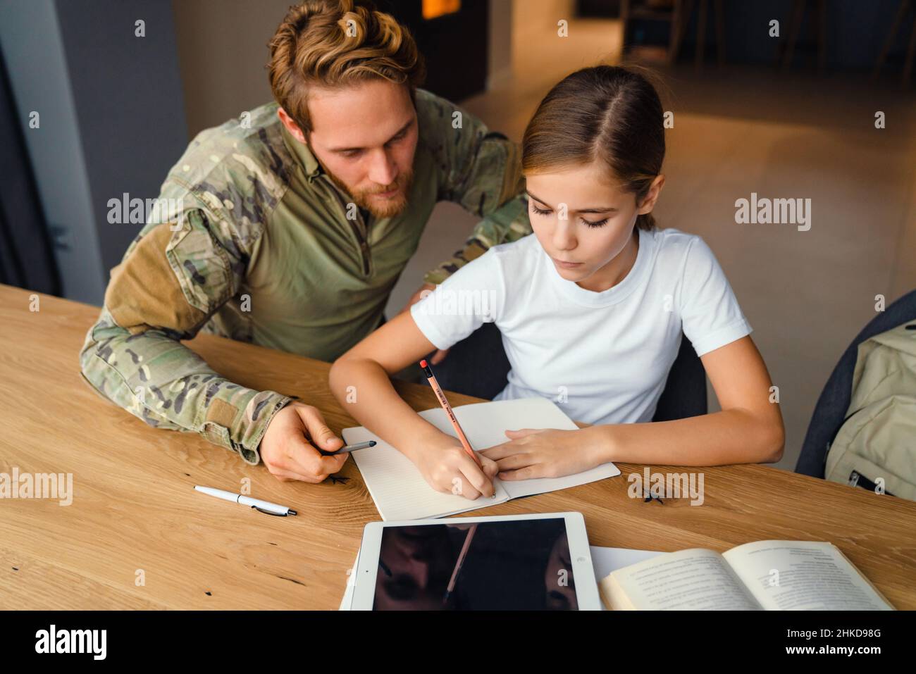 Masculine focused military man doing homework with her daughter at home Stock Photo - Alamy