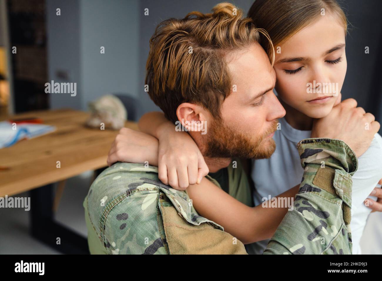 Masculine sad military man hugging her upset daughter indoors Stock ...