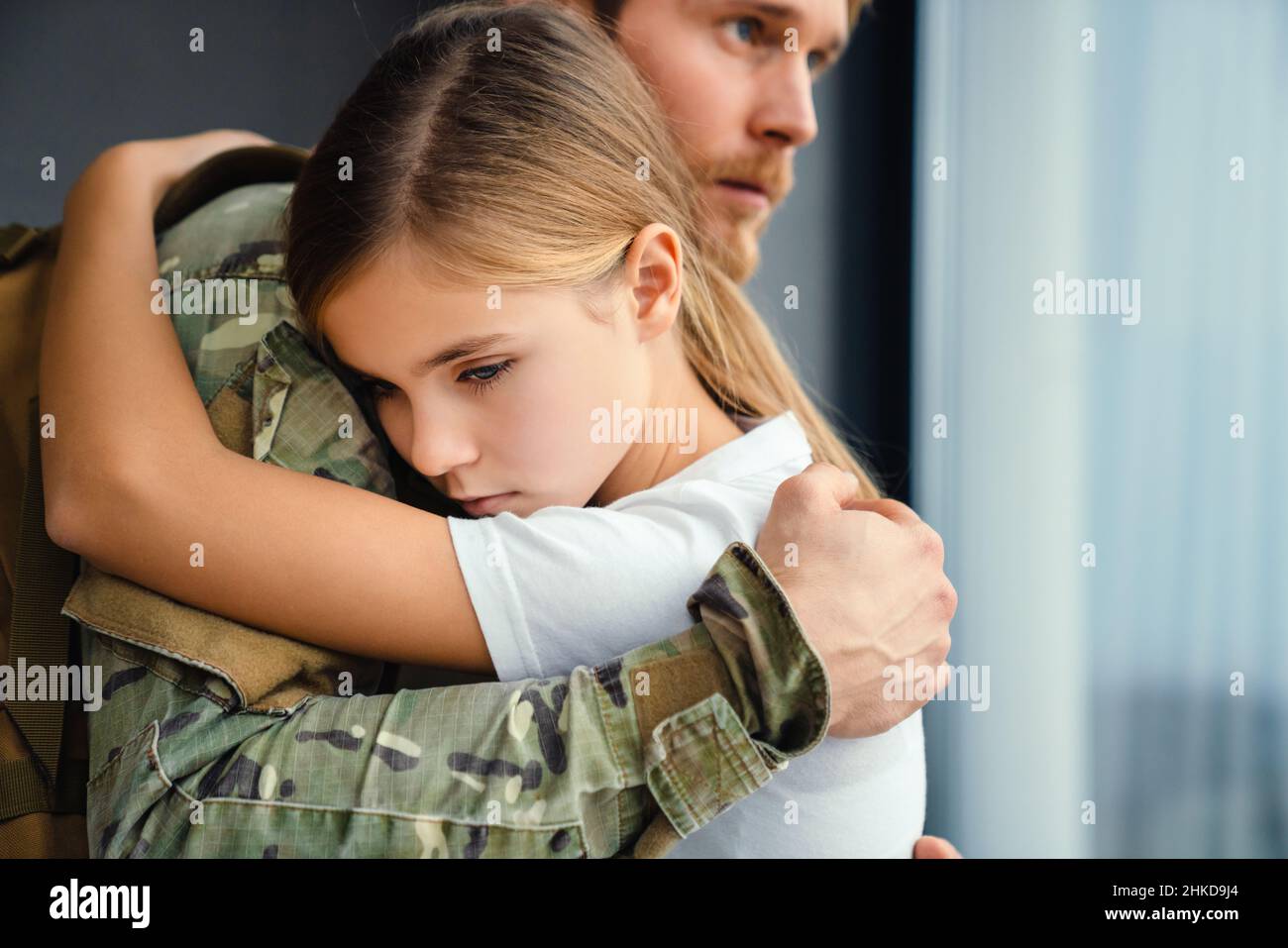 Masculine sad military man hugging her upset daughter indoors Stock ...