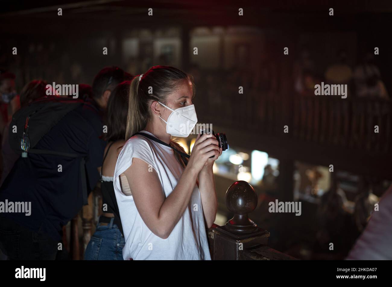 Young girl wearing a face mask taking photos at an indoor theatrical ...