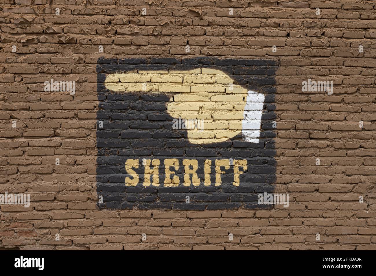 Old west sign of a hand indicating Sheriff painted on an exposed brick ...