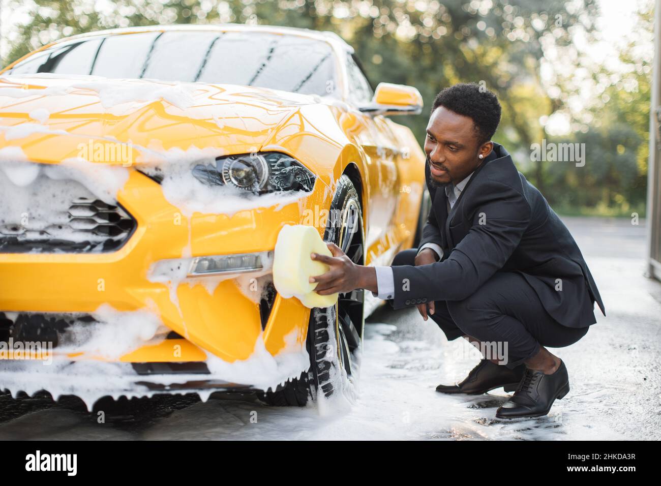 Car washing outdoors ar self wash service station. Handsome African Confident male entrepreneur in cin business suit washing his modern sport car hea Stock Photo Alamy