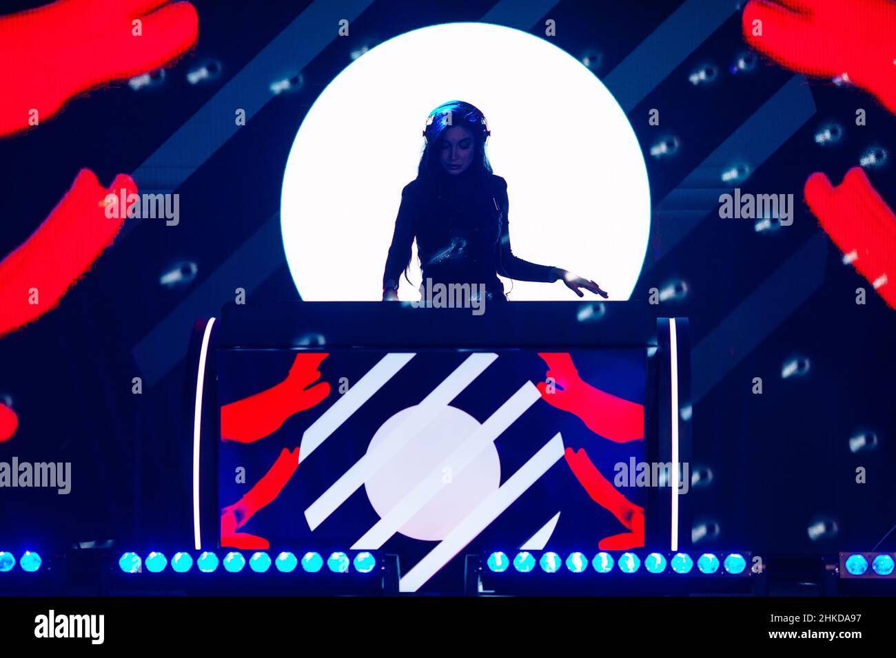 Pretty young disc jockey girl mixing music and dancing. on colorful ...