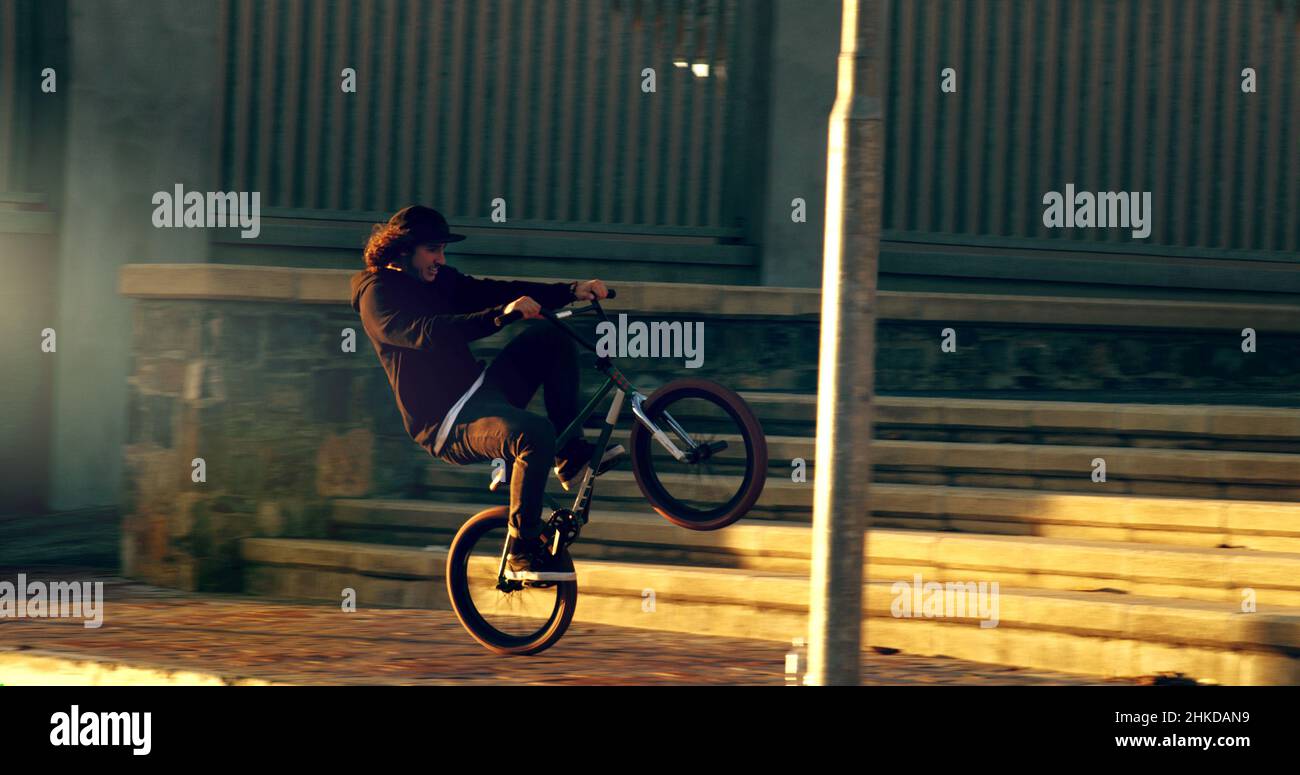 Popping a wheelie. Full length shot of a young male BMX rider doing ...