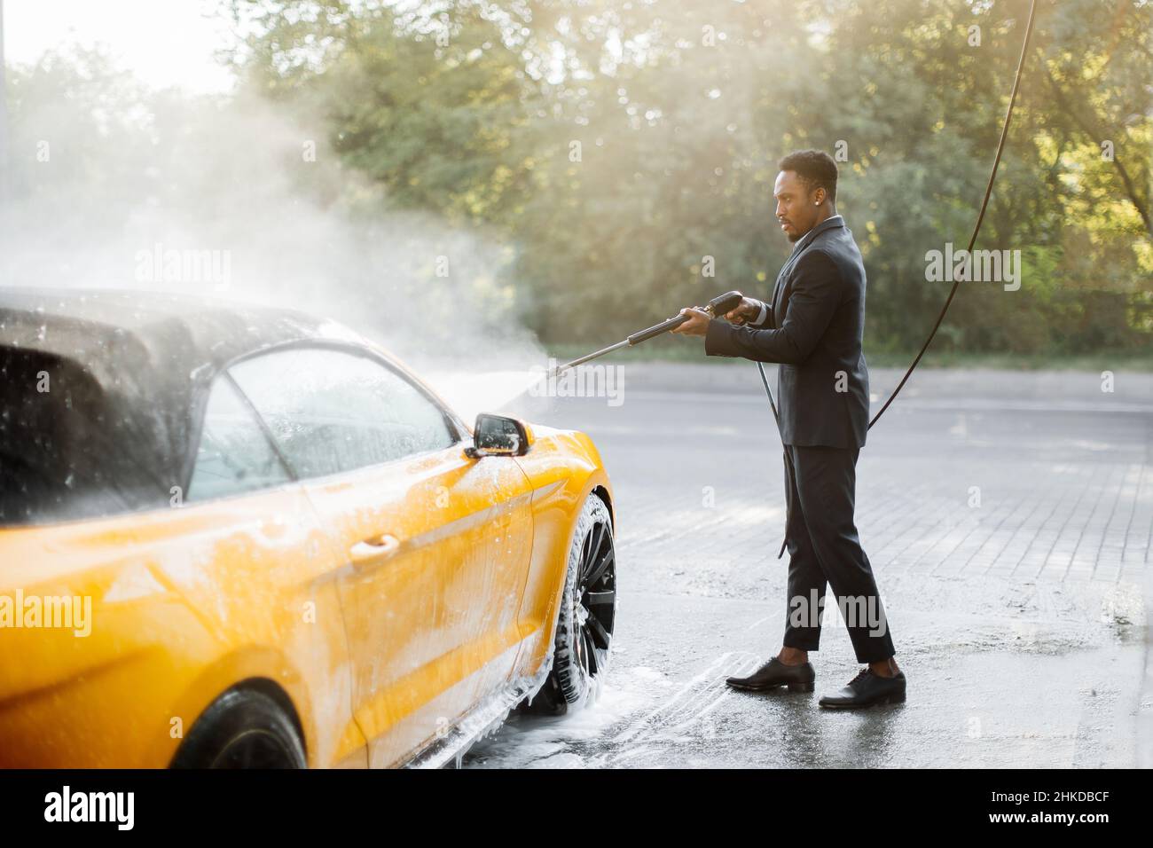 African stylish young focused man in business suit washing his modern ...
